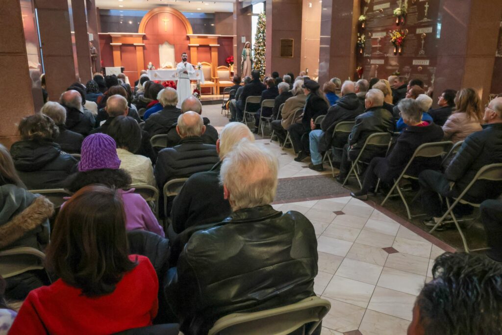 Families remember loved ones during Advent Mass at Holy Cross Cemetery ...