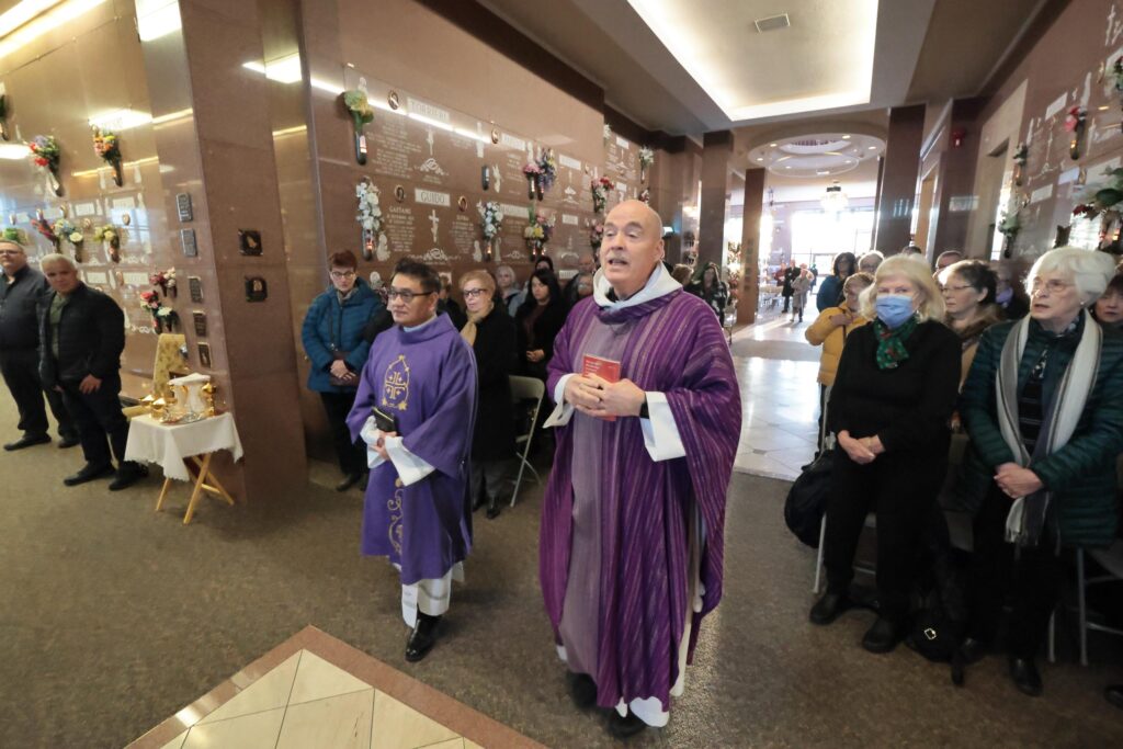 Families remember loved ones during Advent Mass at Holy Cross Cemetery ...