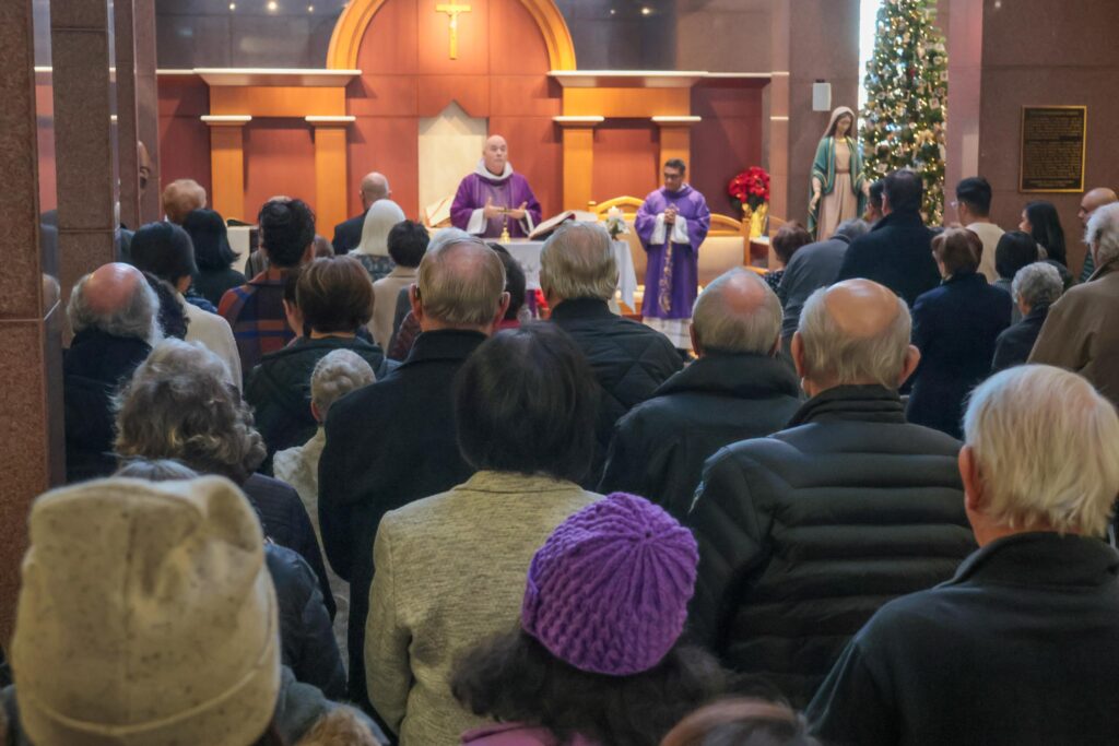 Families remember loved ones during Advent Mass at Holy Cross Cemetery ...