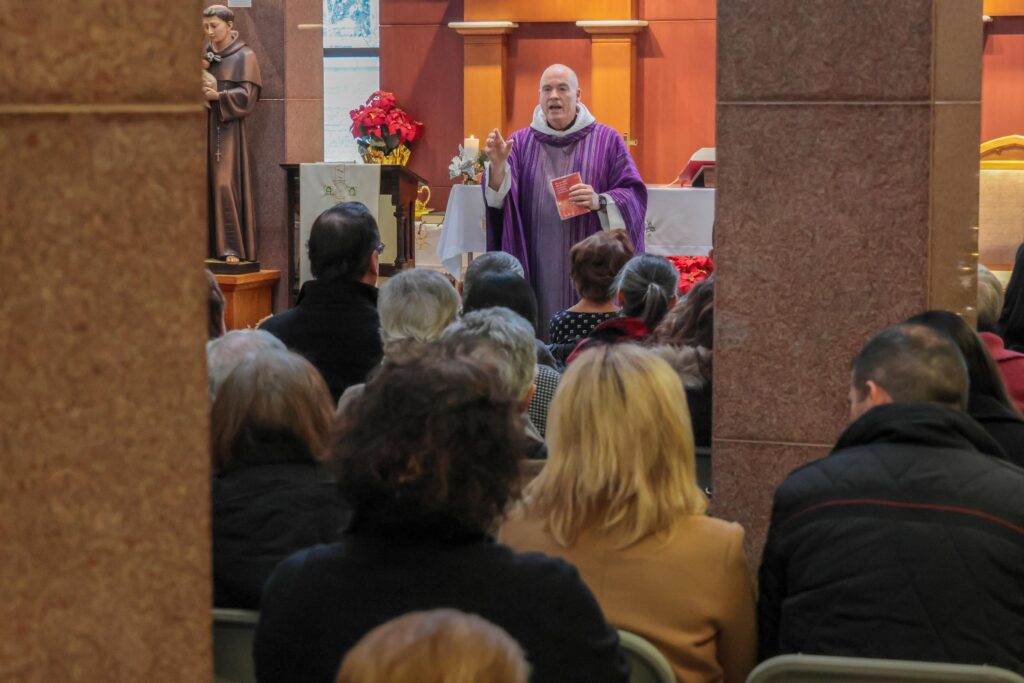 Families remember loved ones during Advent Mass at Holy Cross Cemetery ...
