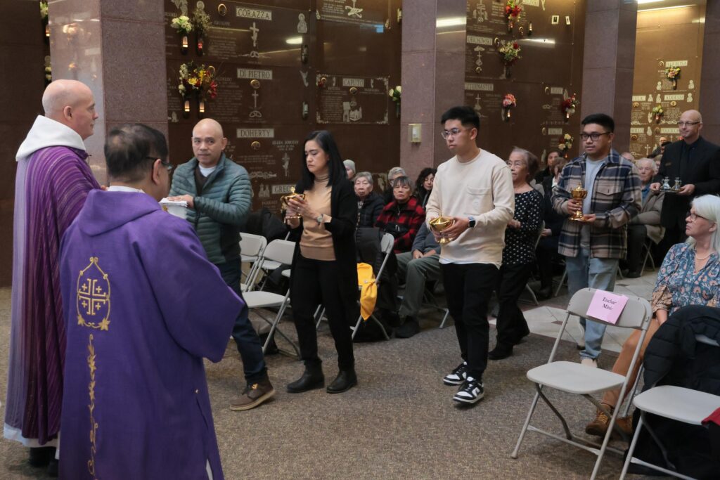 Families remember loved ones during Advent Mass at Holy Cross Cemetery ...
