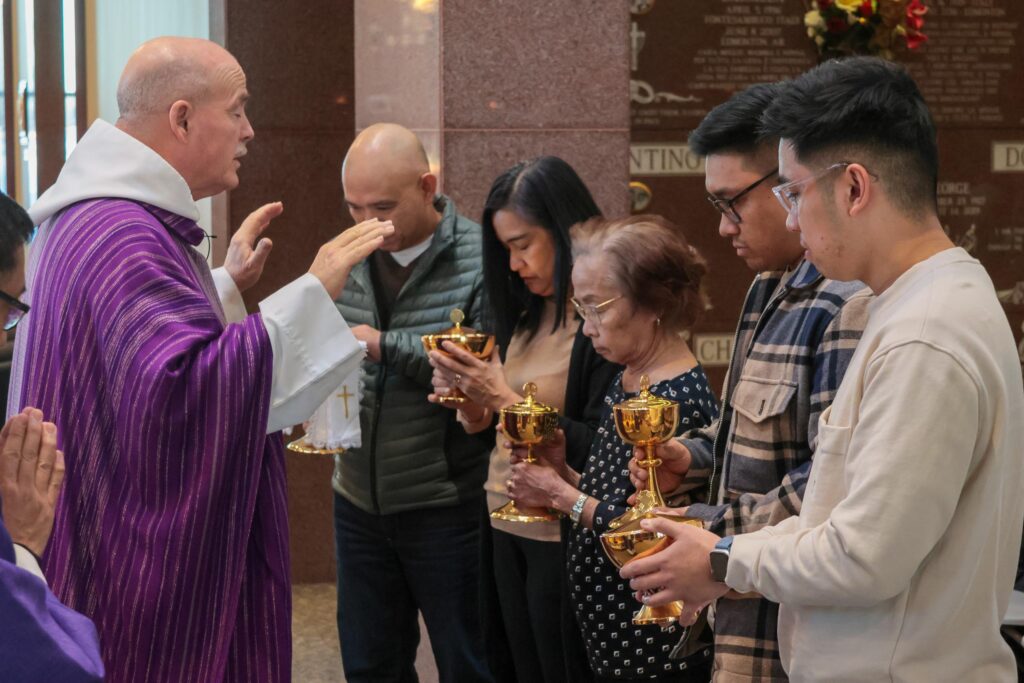 Families remember loved ones during Advent Mass at Holy Cross Cemetery ...