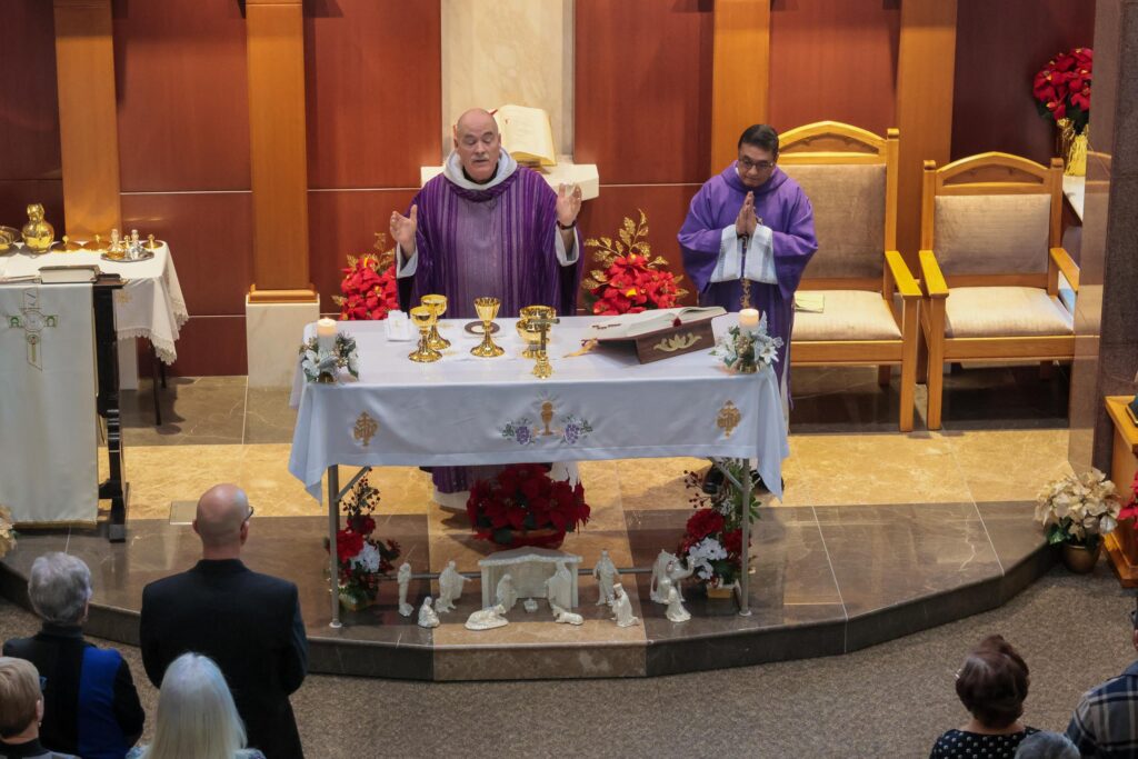 Families remember loved ones during Advent Mass at Holy Cross Cemetery ...
