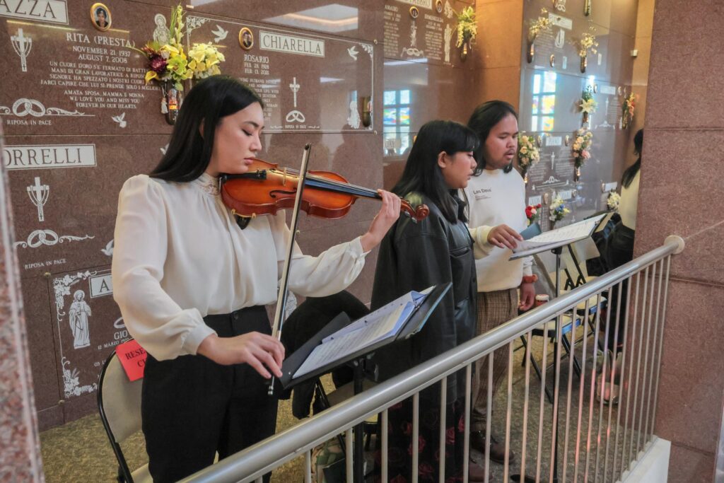 Families remember loved ones during Advent Mass at Holy Cross Cemetery ...