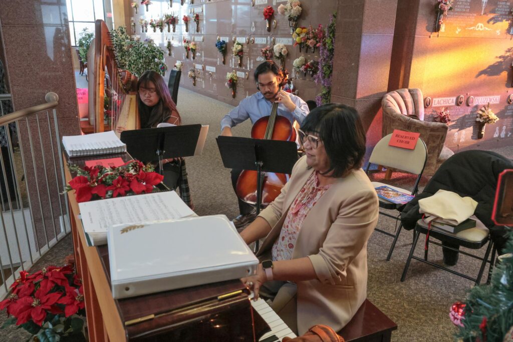Families remember loved ones during Advent Mass at Holy Cross Cemetery ...