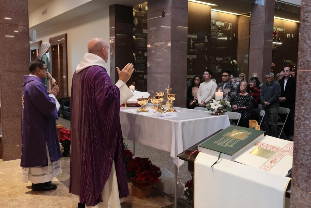 Families remember loved ones during Advent Mass at Holy Cross Cemetery ...