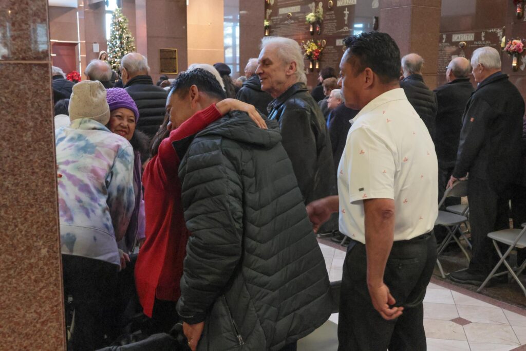 Families remember loved ones during Advent Mass at Holy Cross Cemetery ...