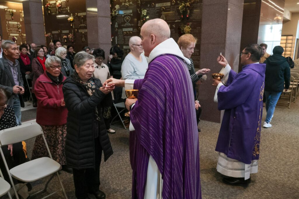 Families remember loved ones during Advent Mass at Holy Cross Cemetery ...