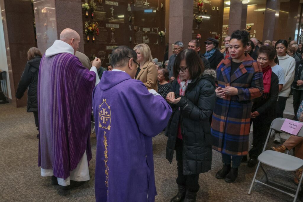 Families remember loved ones during Advent Mass at Holy Cross Cemetery ...