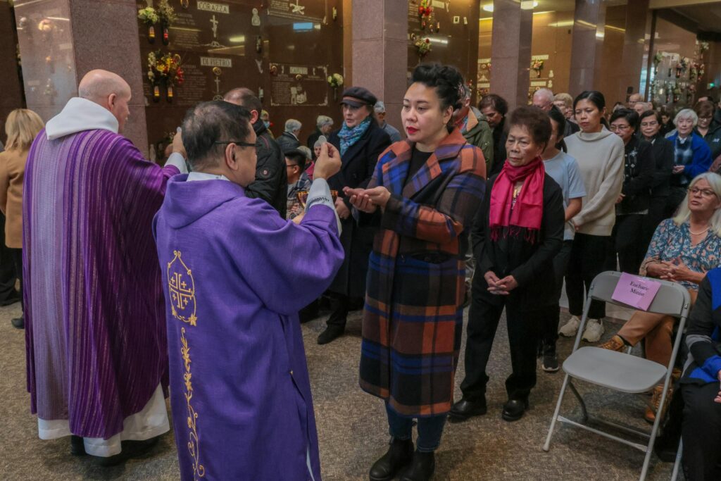 Families remember loved ones during Advent Mass at Holy Cross Cemetery ...