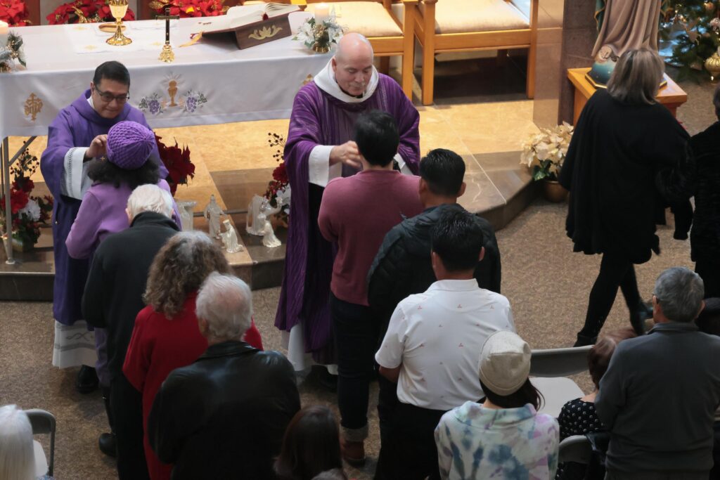 Families remember loved ones during Advent Mass at Holy Cross Cemetery ...